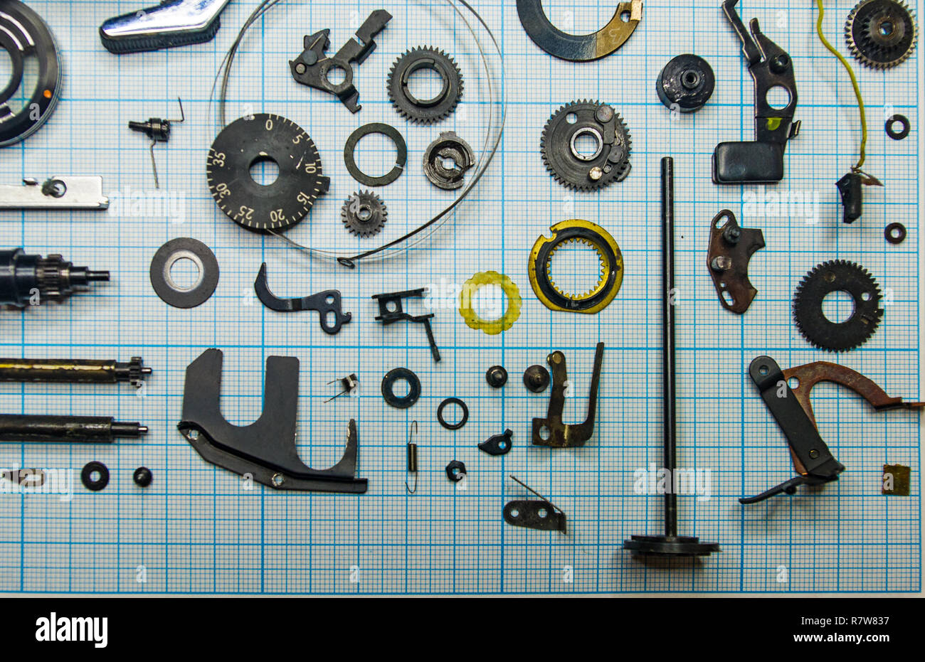 parts are completely disassembled old retro film SLR camera on graph ...