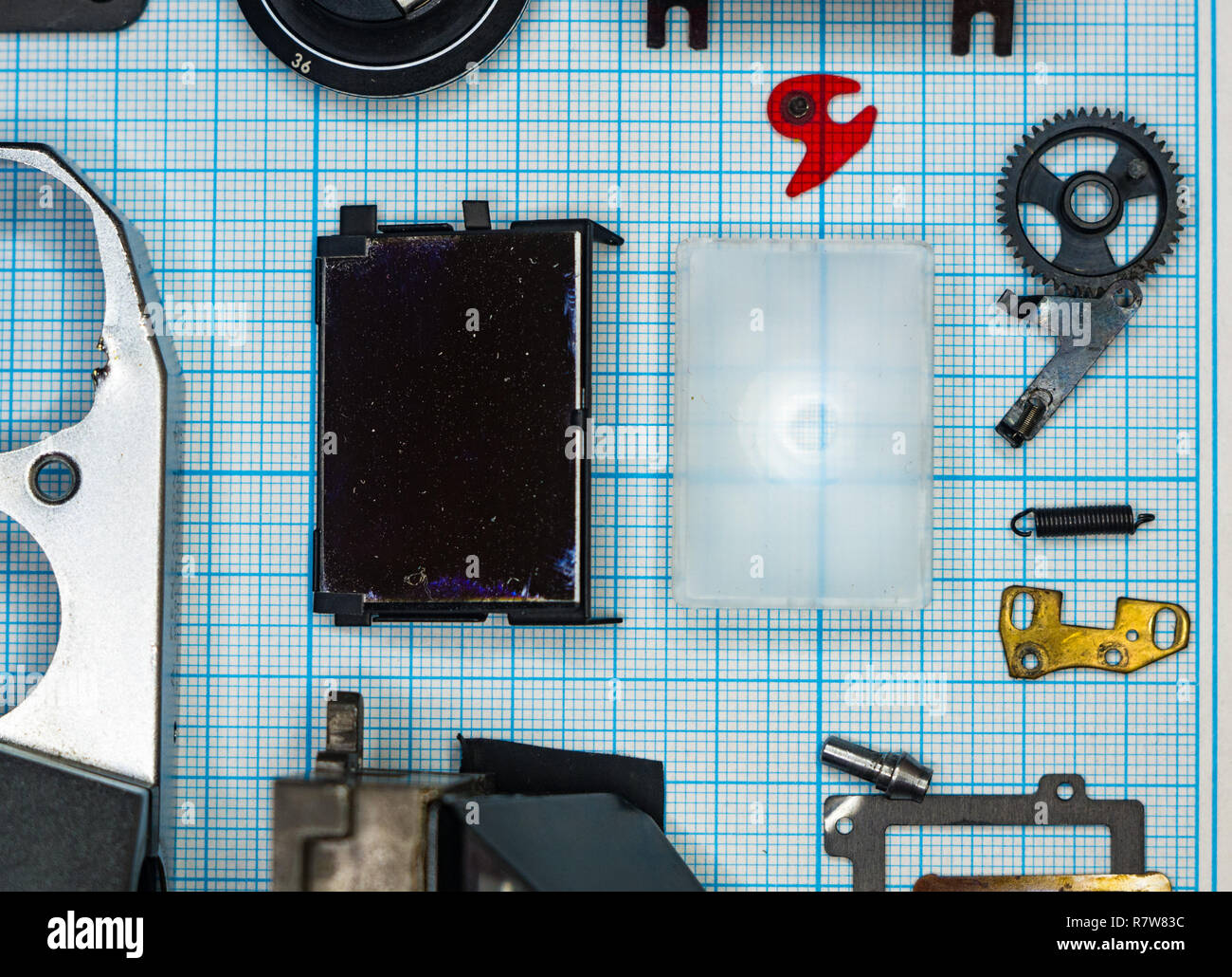 parts are completely disassembled old retro film SLR camera on graph ...