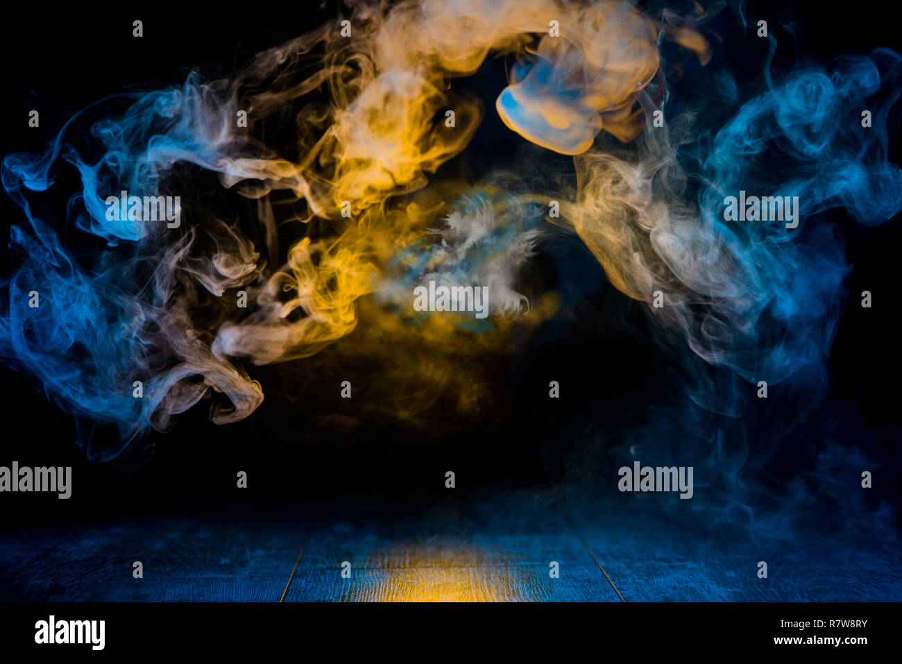 yellow and blue smoke patterns at dark background Stock Photo - Alamy