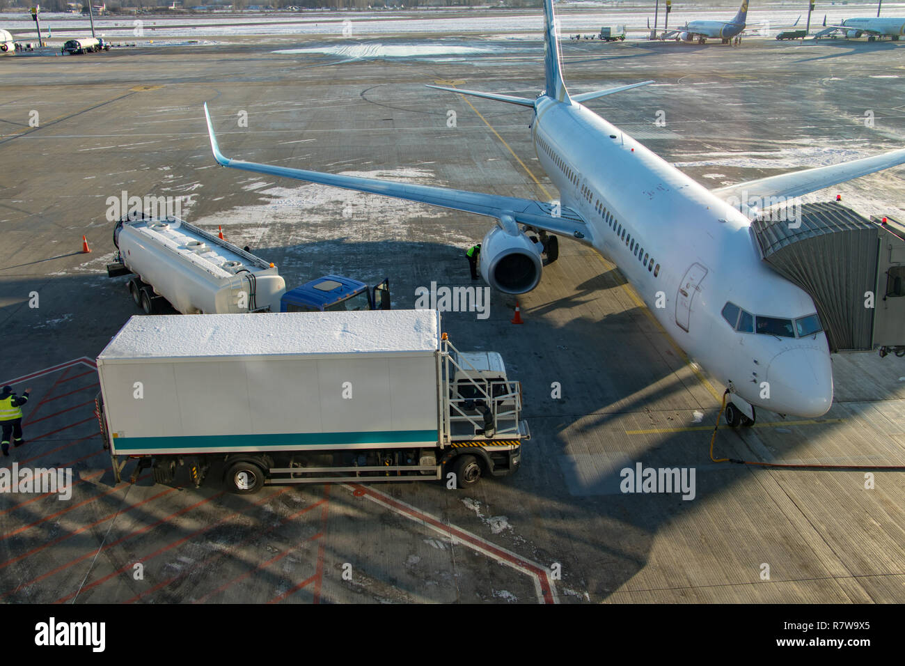 Airplane stands on a runway and prepare for flight. Deliveries of food ...