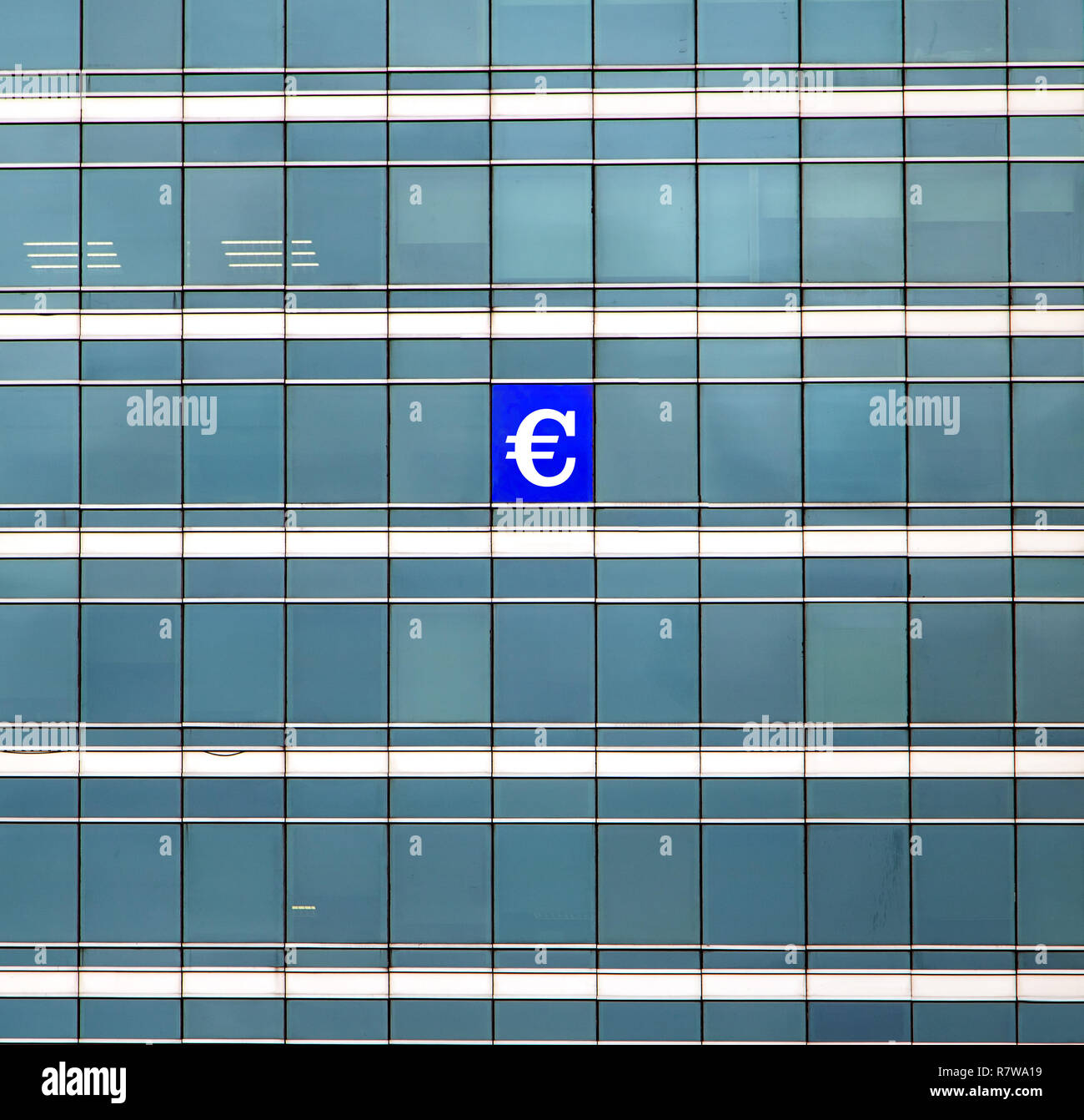 The symbol of the euro currency on the building's window. The glass ...