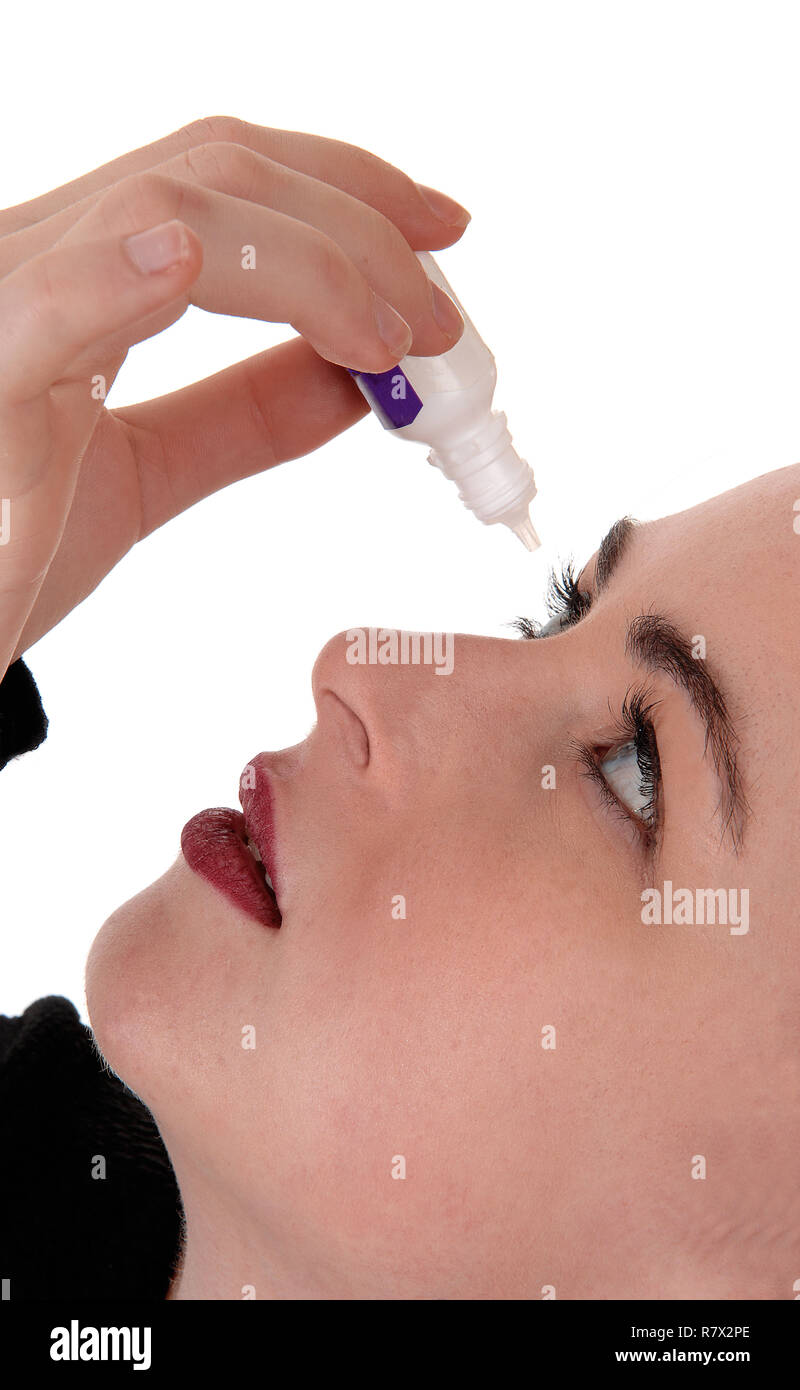 A close up image of a young woman putting eye drops is her dry eye ...