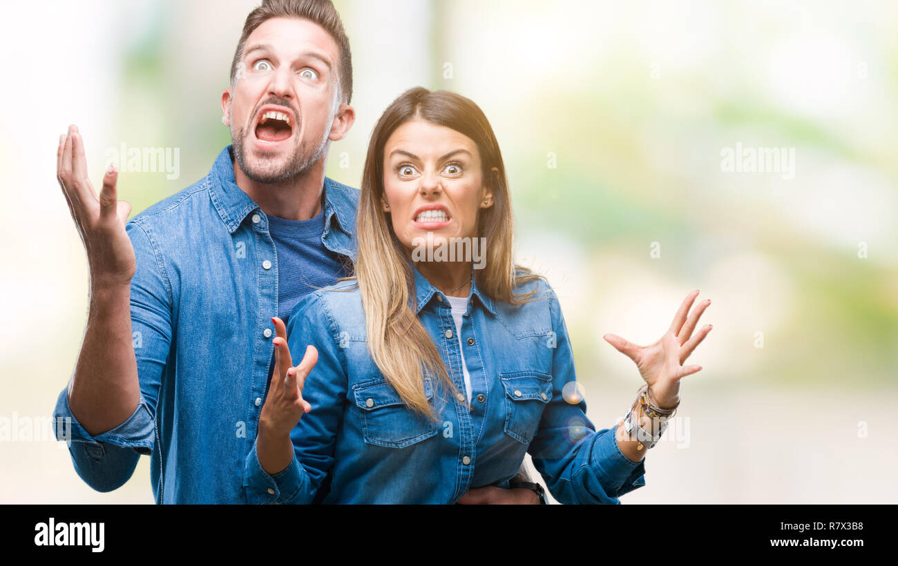Young couple in love over isolated background crazy and mad shouting ...