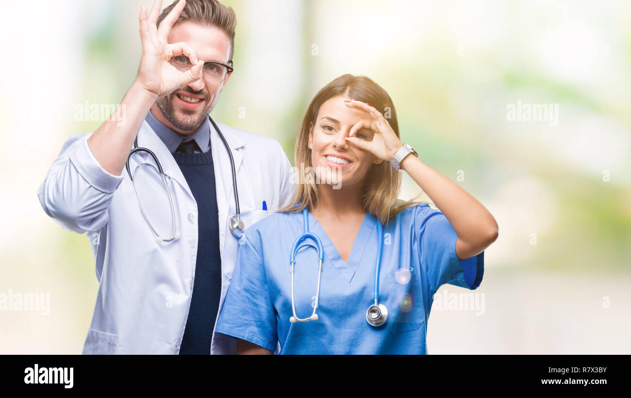 Young couple of doctor and surgeon over isolated background doing ok ...