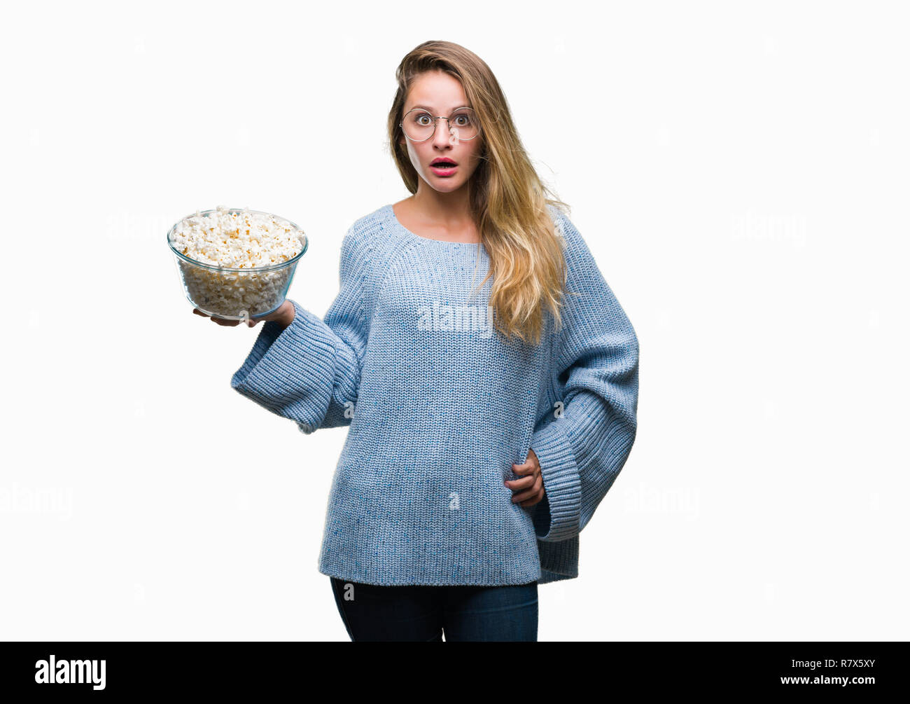 Young beautiful blonde woman eating popcorn over isolated background ...