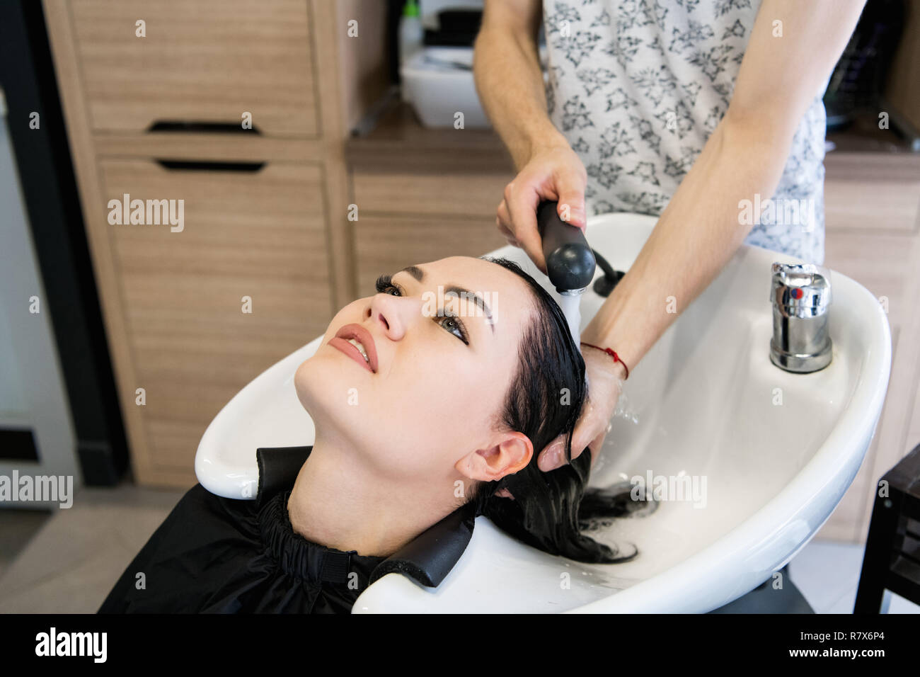 Female client getting hair washed by hairstylist in parlor Stock Photo ...