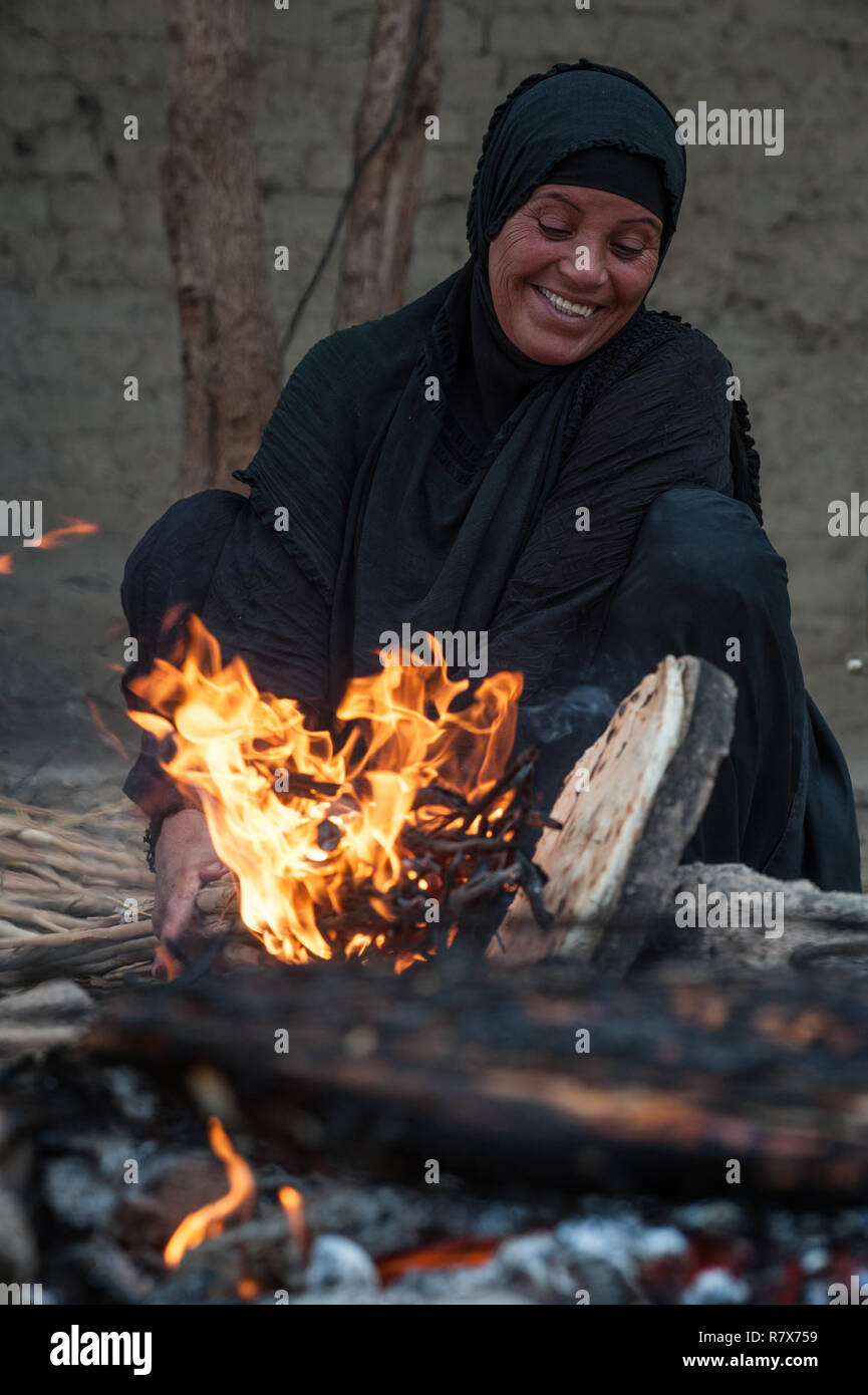 Um Haidar seen making rice bread in the traditional way over an open ...