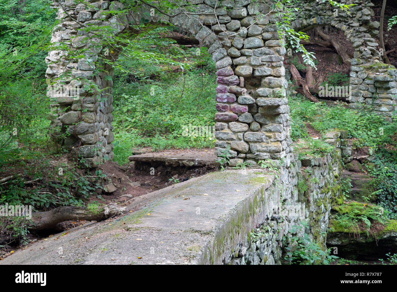 An old collapsed driveway passing through decaying arches falling apart ...