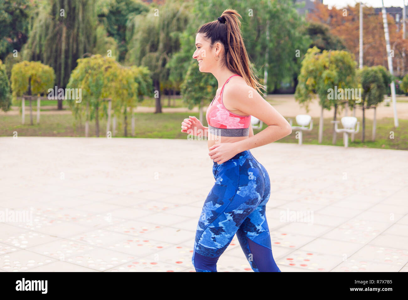 Young beautiful fit woman is running in the park. Healthy concept Stock ...