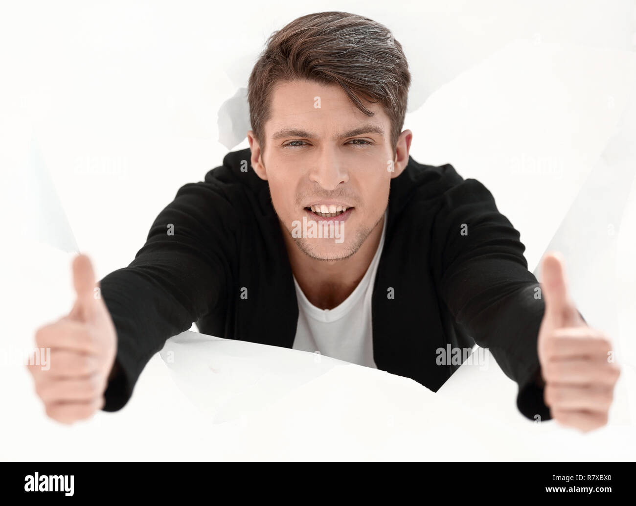 man breaking through paper wall and showing thumbs up Stock Photo - Alamy