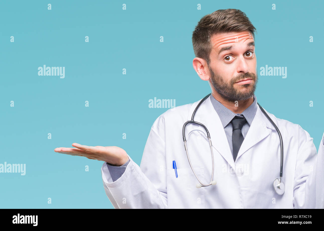 Young handsome doctor man over isolated background clueless and ...