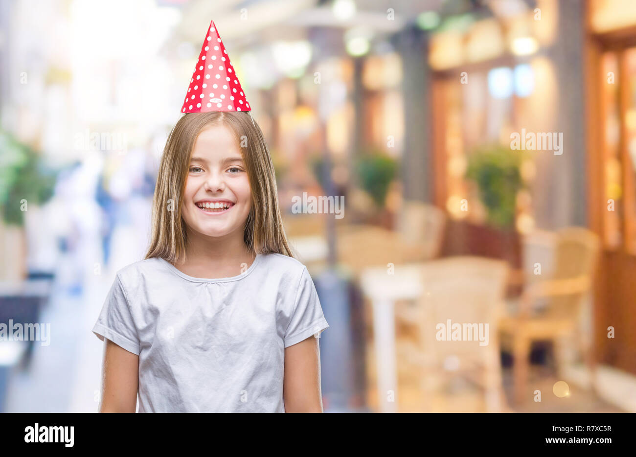 Young beautiful girl wearing birthday cap over isolated background with ...