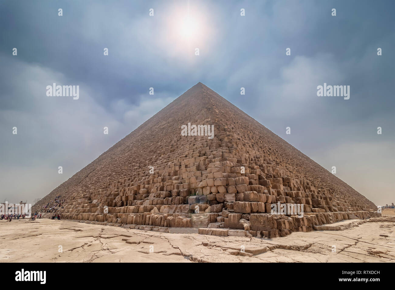 The Pyramid of Cheops illuminated by the sun in backlight, with people ...