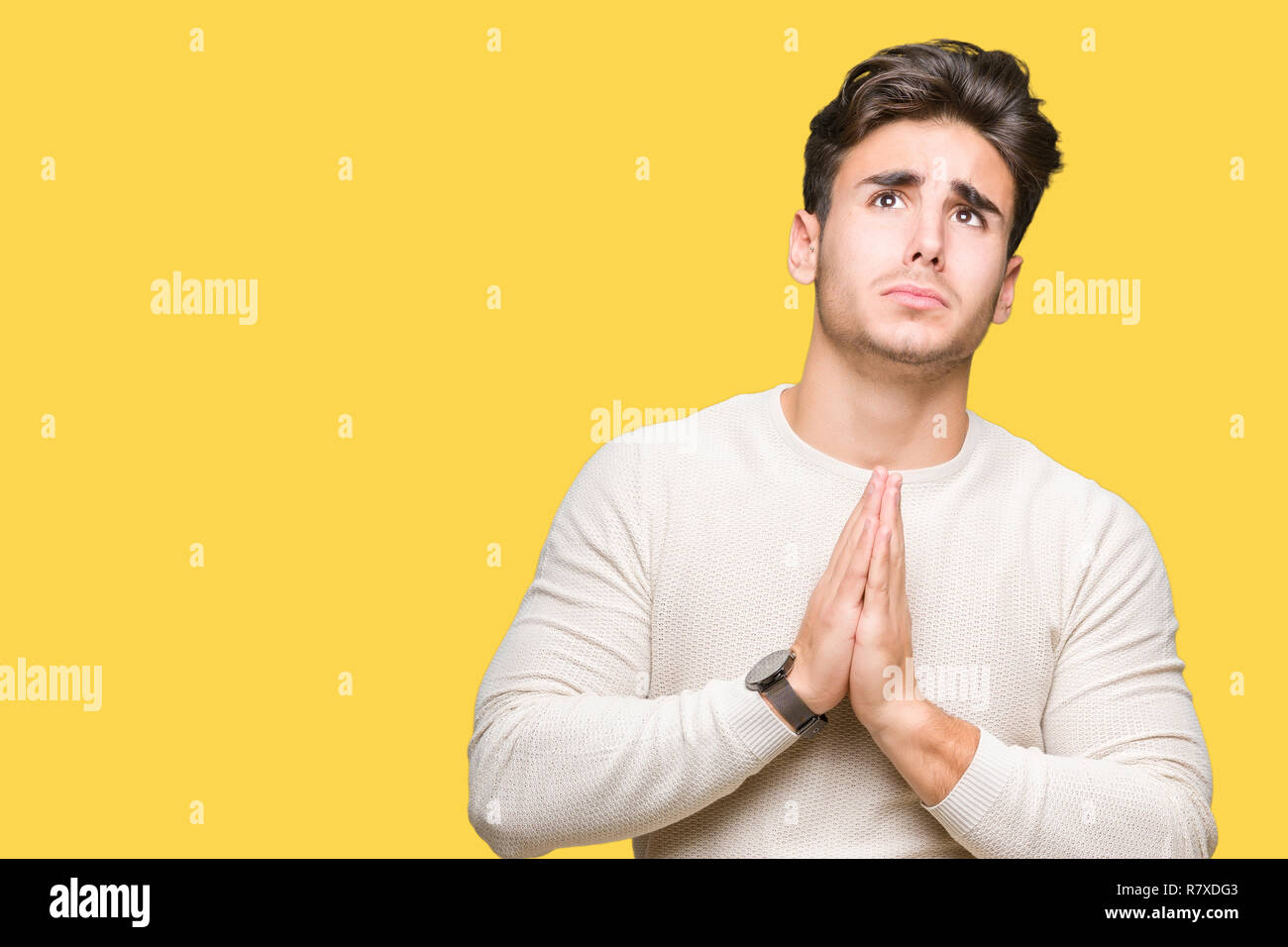 Young handsome man over isolated background begging and praying with ...
