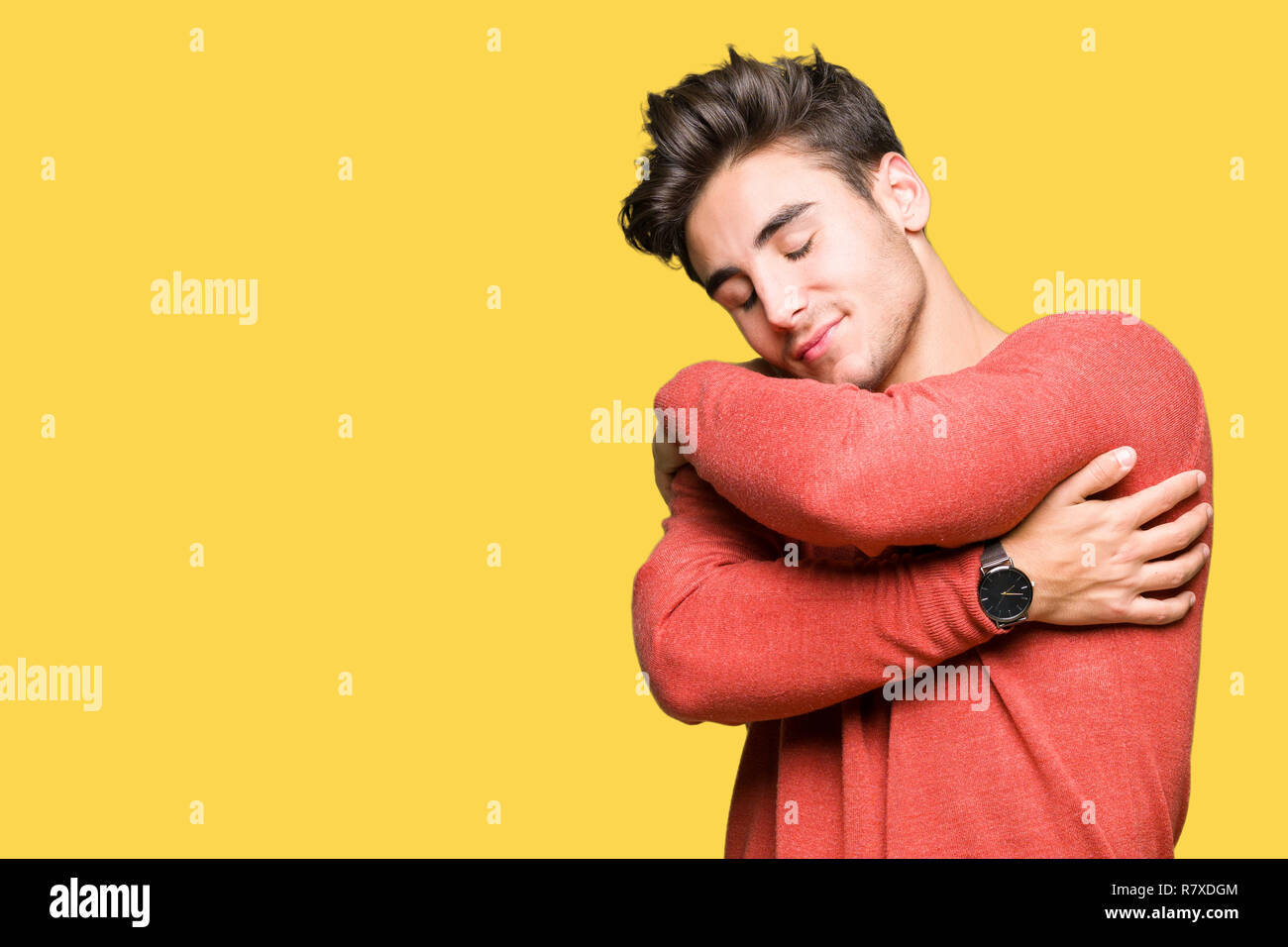 Young handsome man over isolated background Hugging oneself happy and ...
