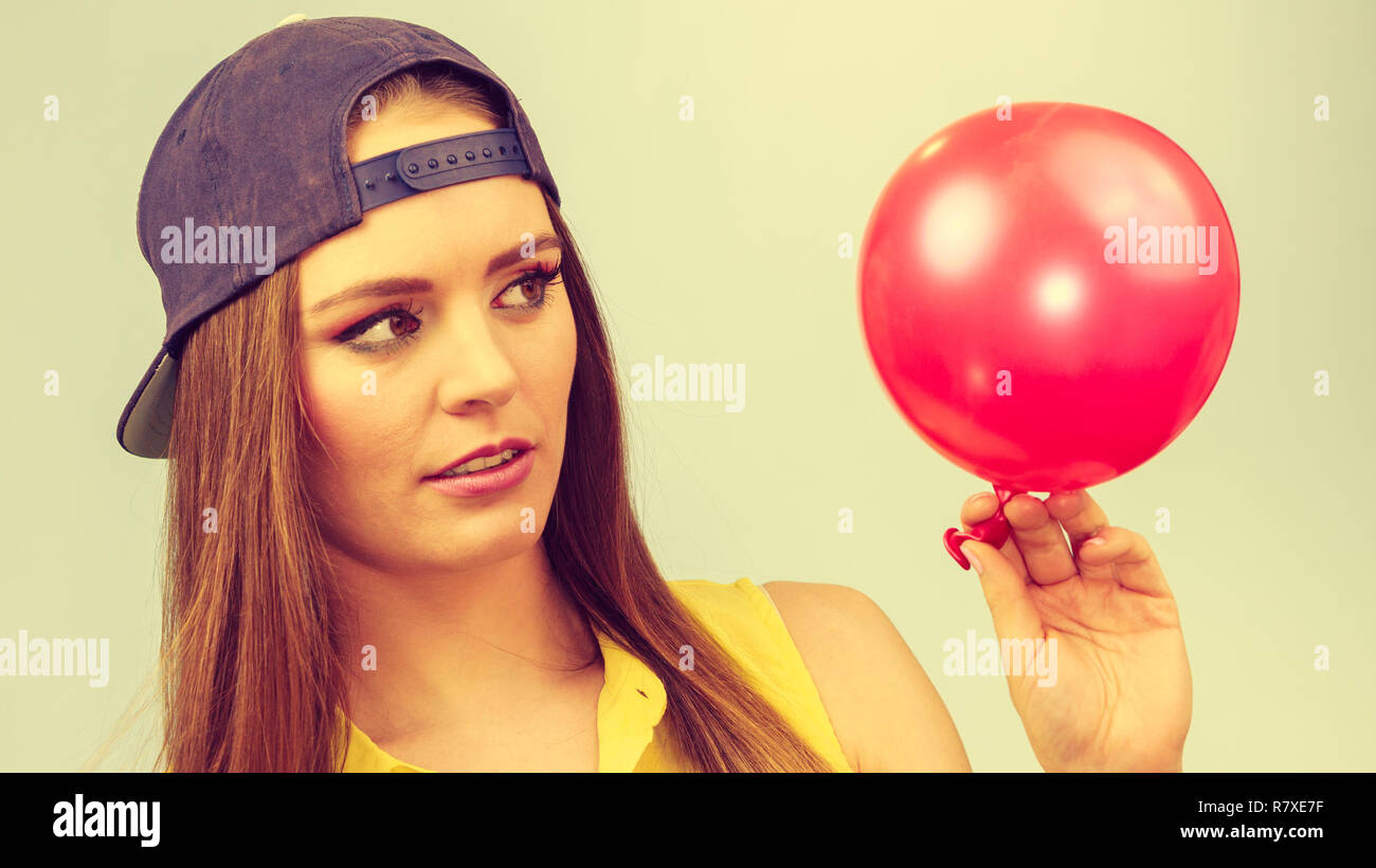 Teenage girl making funny silly faces. Young trendy woman in jeans cap ...