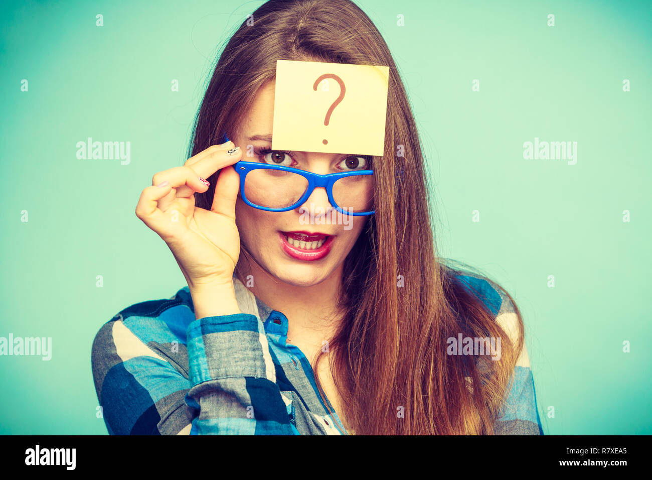 Thinking woman with big nerdy eyeglasses and question mark on forehead ...