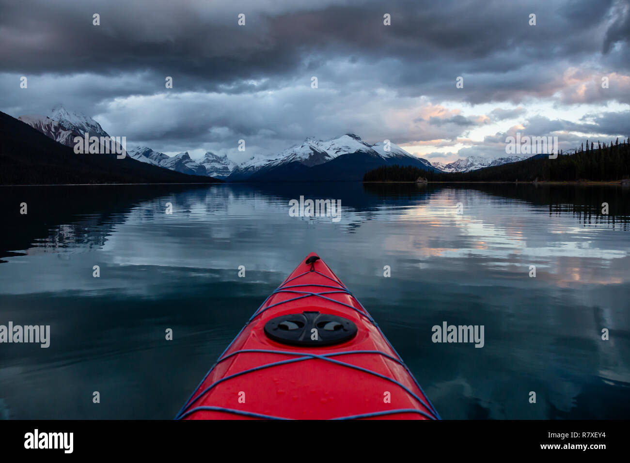 Kayaking in a peaceful and calm glacier lake during a vibrant cloudy ...