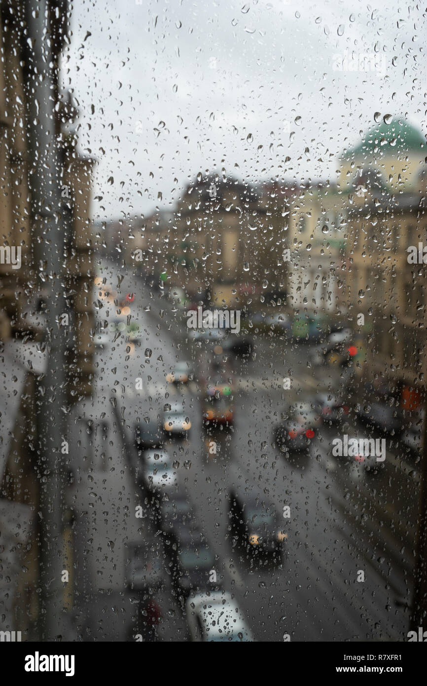 Defocussed traffic viewed through a car windscreen covered in rain ...