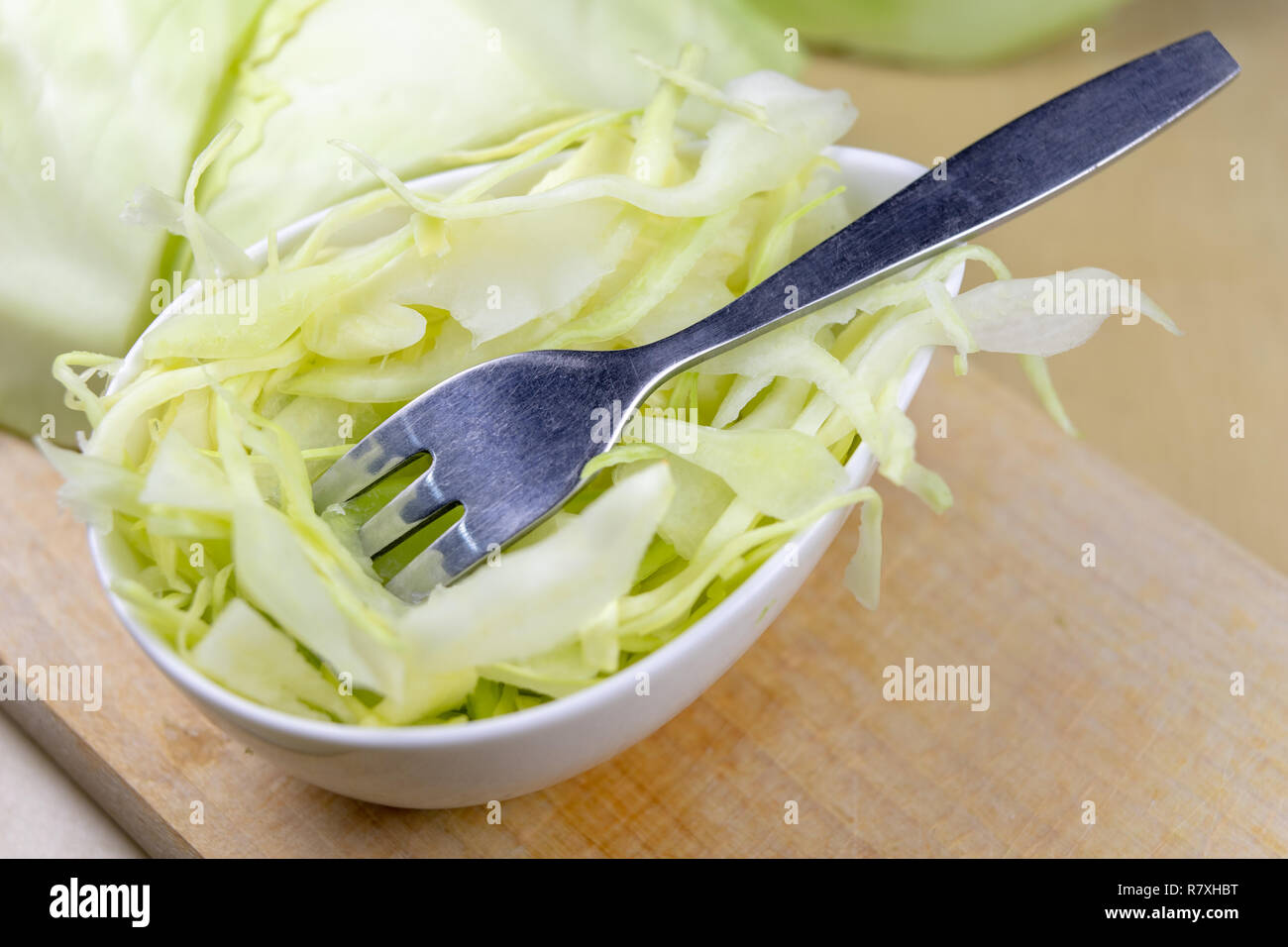 Fresh white cabbage cut into strips on the kitchen table. Vegetables ...