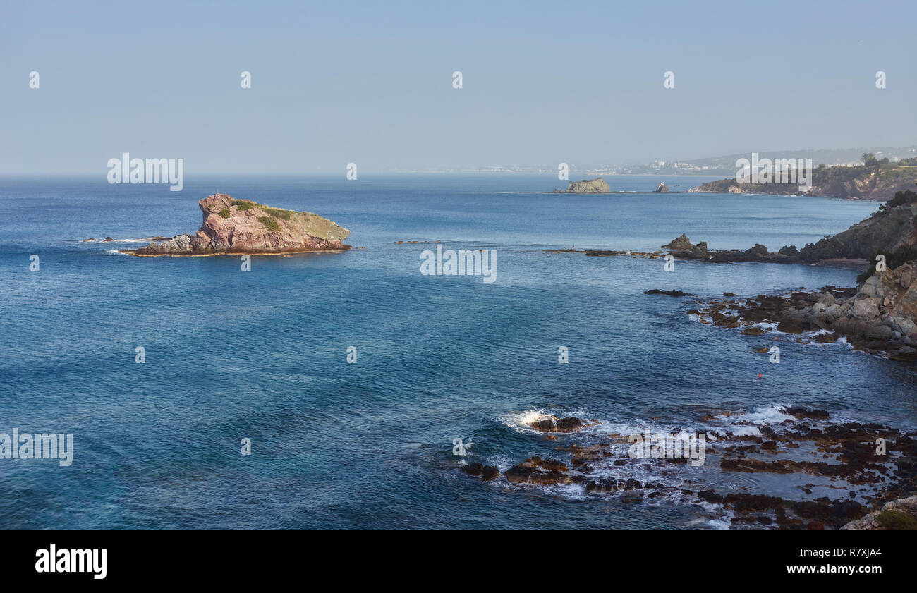 Stones and rocks in forefront with creamy surf ebbing and flowing on ...