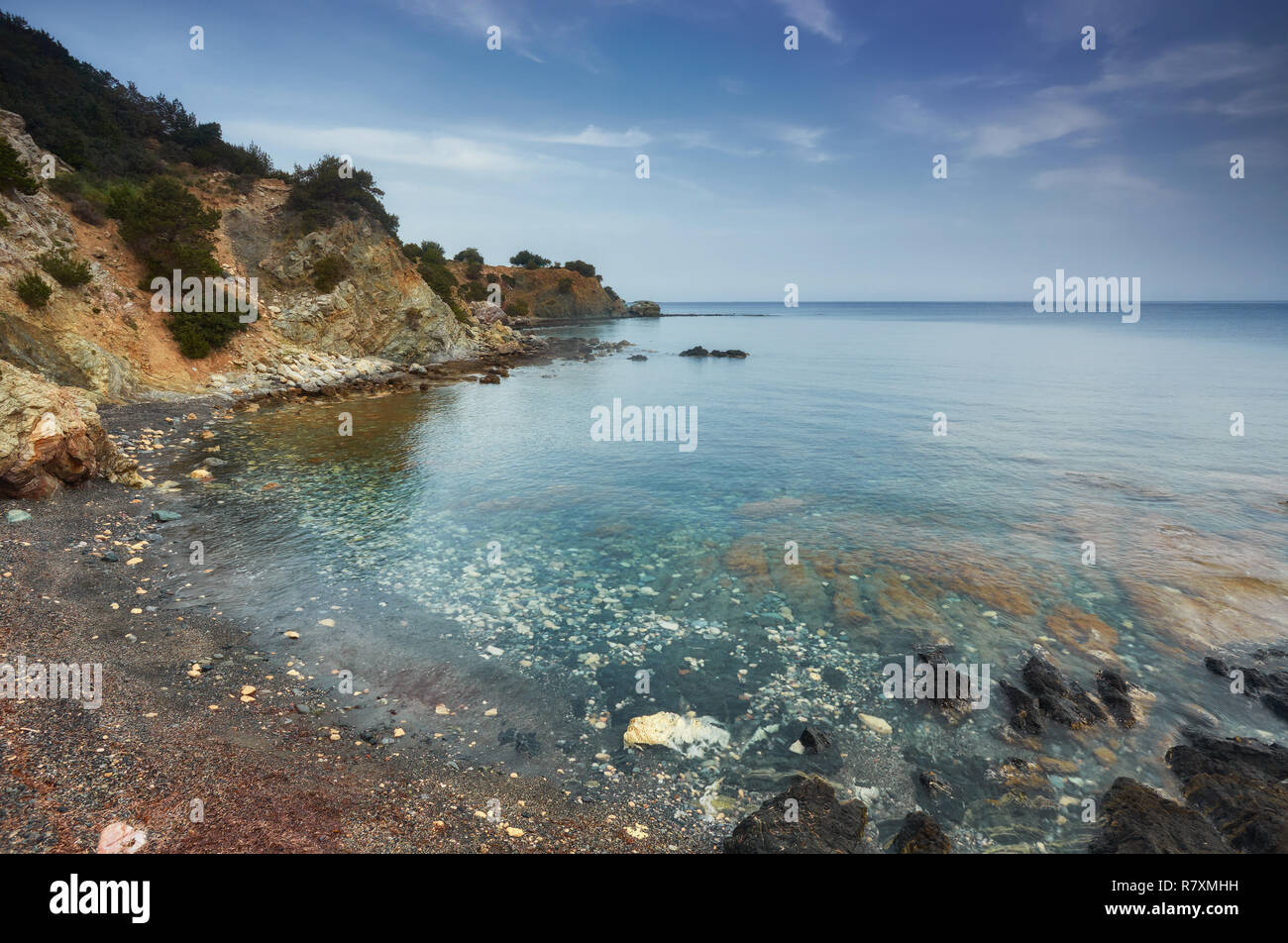 Stones and rocks in forefront with creamy surf ebbing and flowing on ...