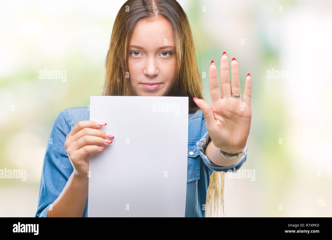 Young caucasian woman holding blank paper sheet over isolated ...