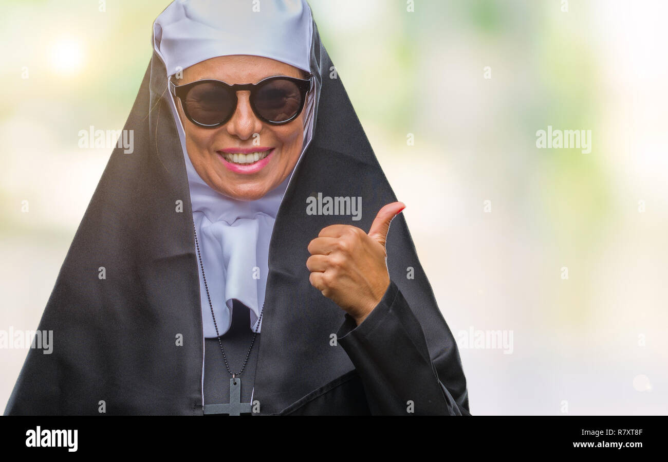 Middle age senior catholic nun woman wearing sunglasses over isolated ...