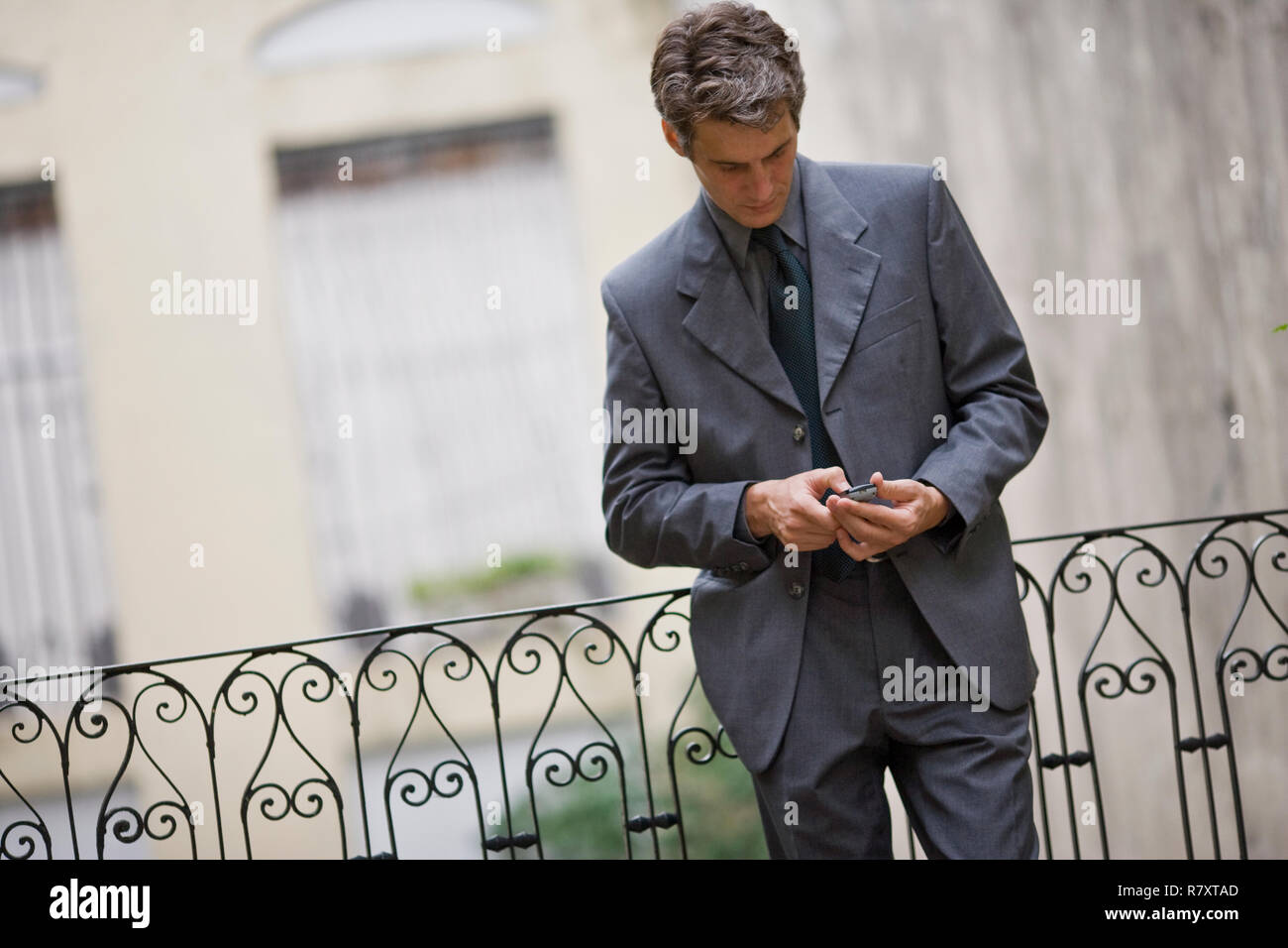 Mid-adult business man texting while outside Stock Photo - Alamy