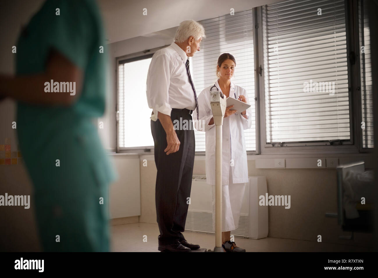 View of a doctor checking his weight on a weighing machine Stock Photo ...