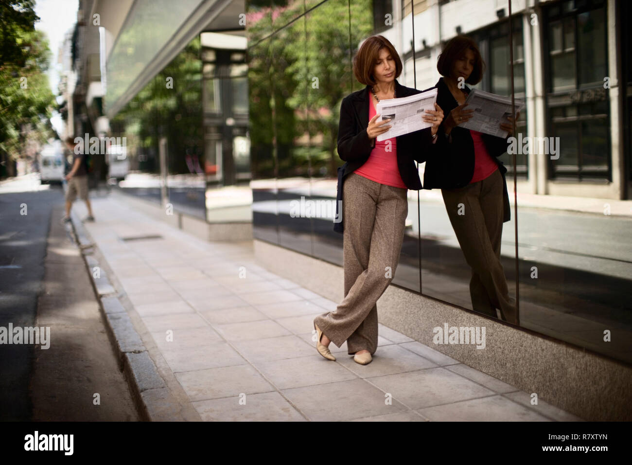 Side view of a stylish woman reading a newspaper Stock Photo - Alamy