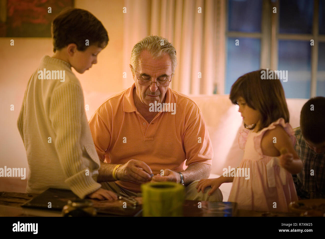 An old man playing with three kids Stock Photo - Alamy