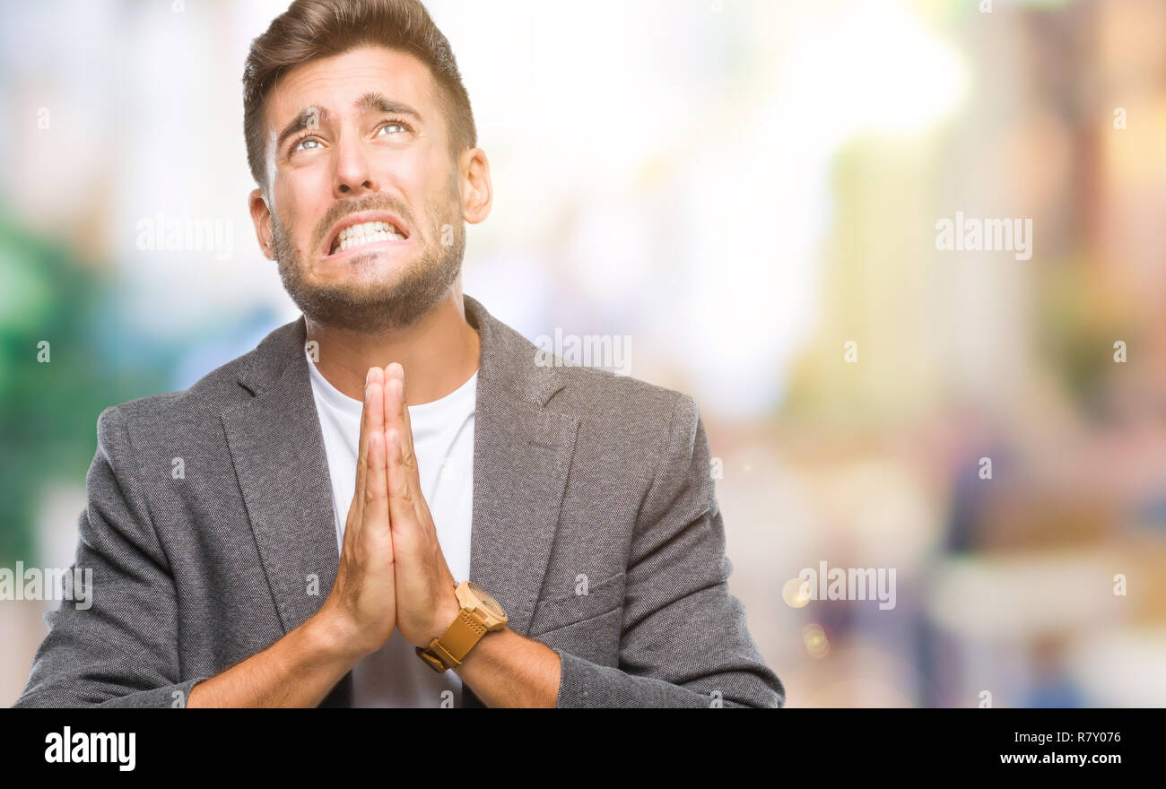 Young handsome business man over isolated background begging and ...