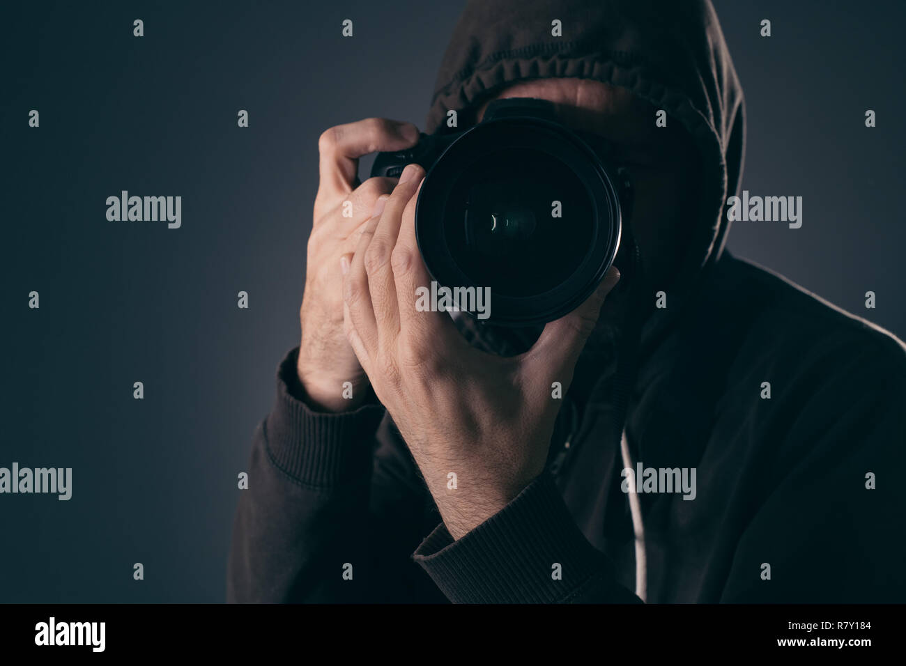 Hooded photographer behind DSLR camera, low key portrait Stock Photo ...