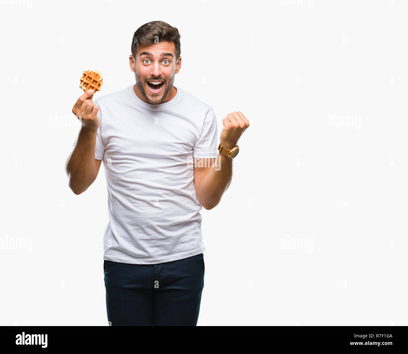 Young handsome man eating a sweet waffle over isolated background ...