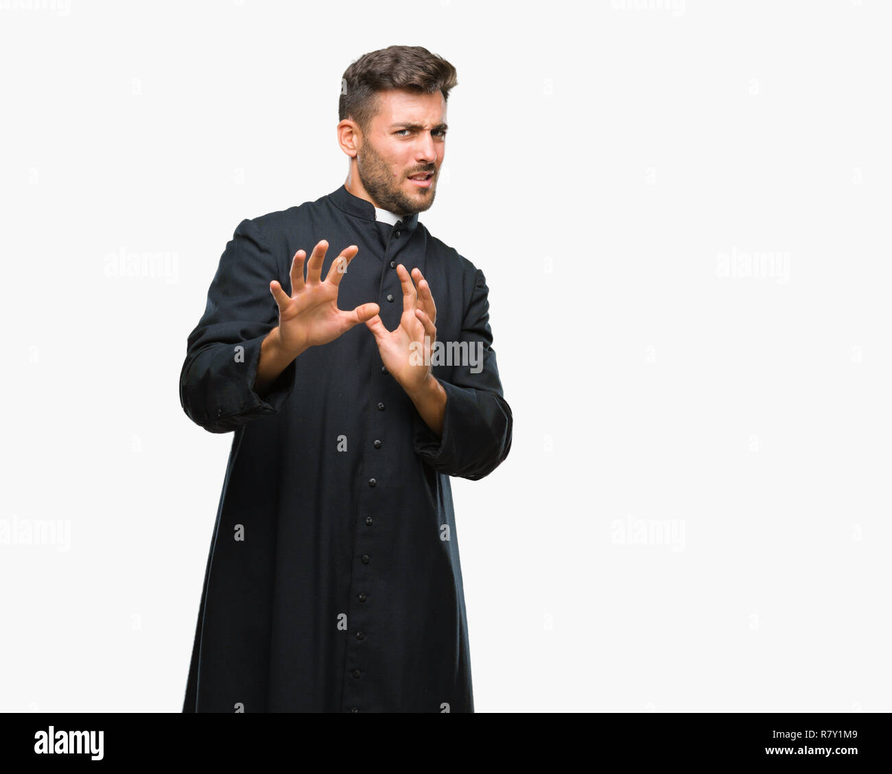 Young catholic christian priest man over isolated background disgusted ...