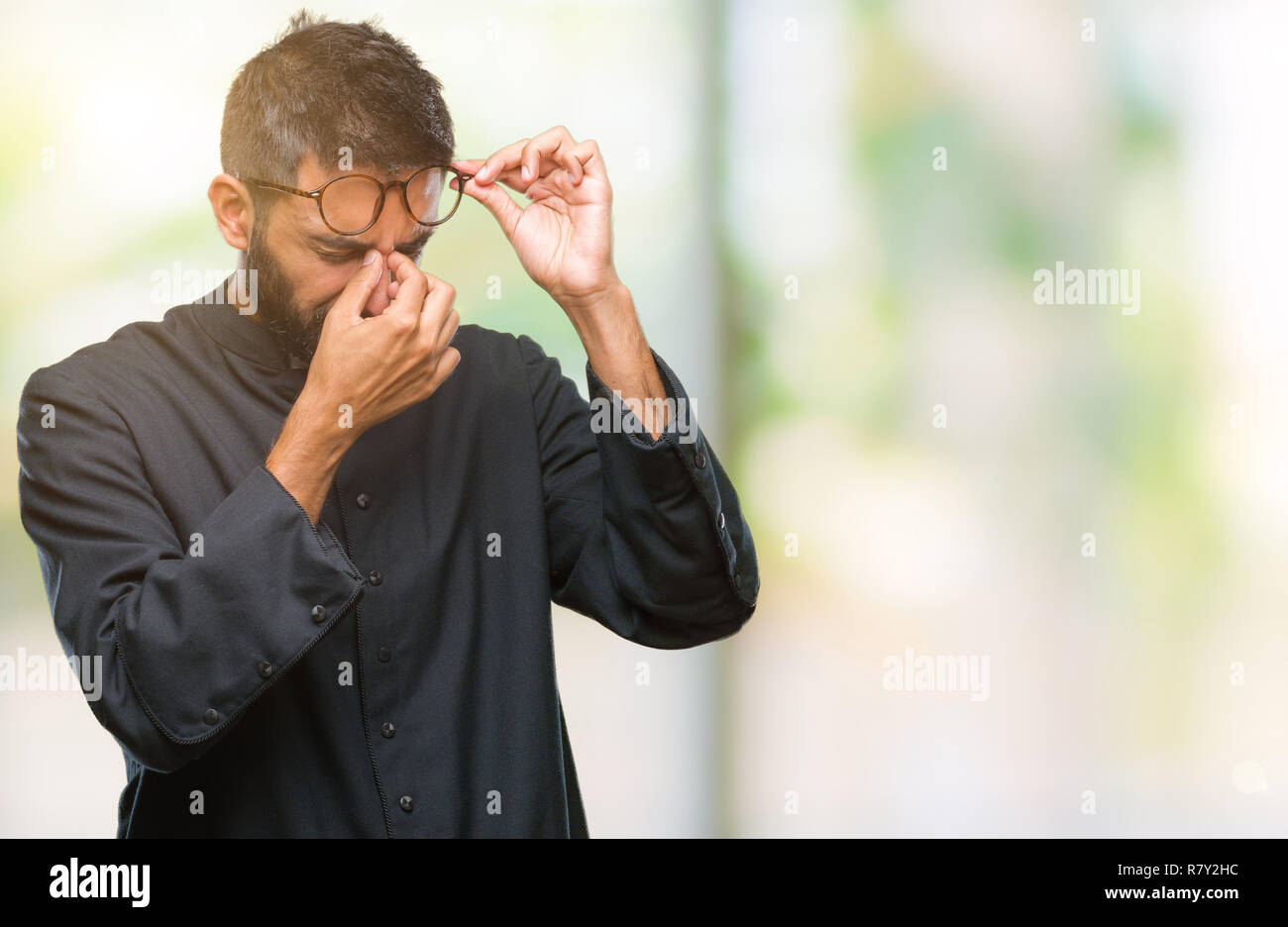 Adult hispanic catholic priest man over isolated background tired ...
