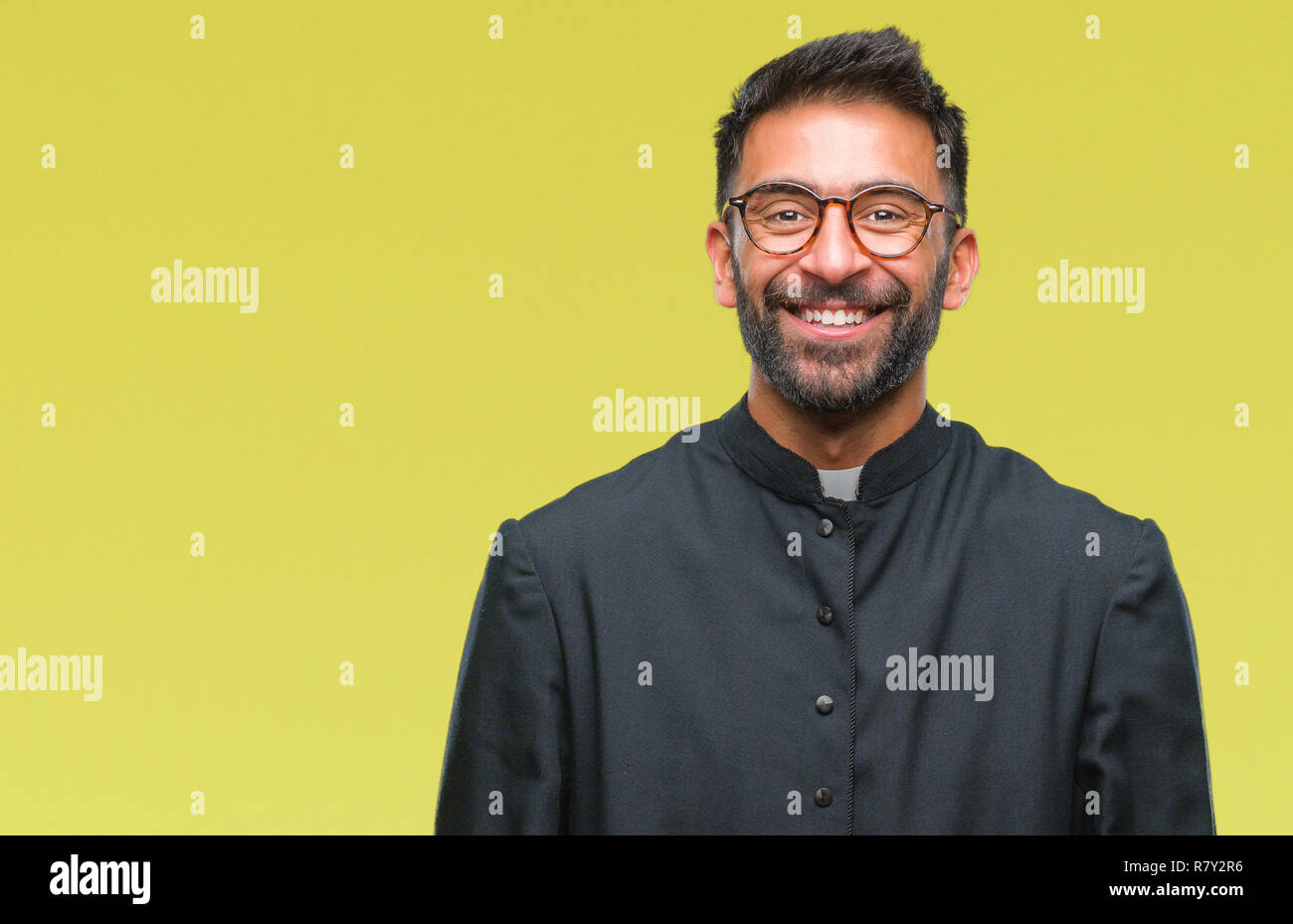 Adult hispanic catholic priest man over isolated background with a ...