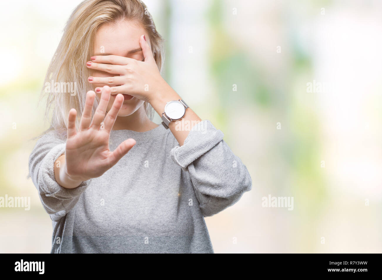 Young blonde woman over isolated background covering eyes with hands ...