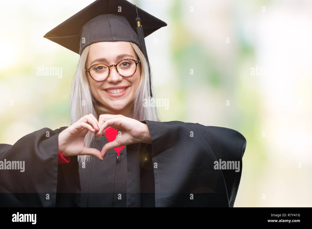 Young blonde woman wearing graduate uniform over isolated background ...