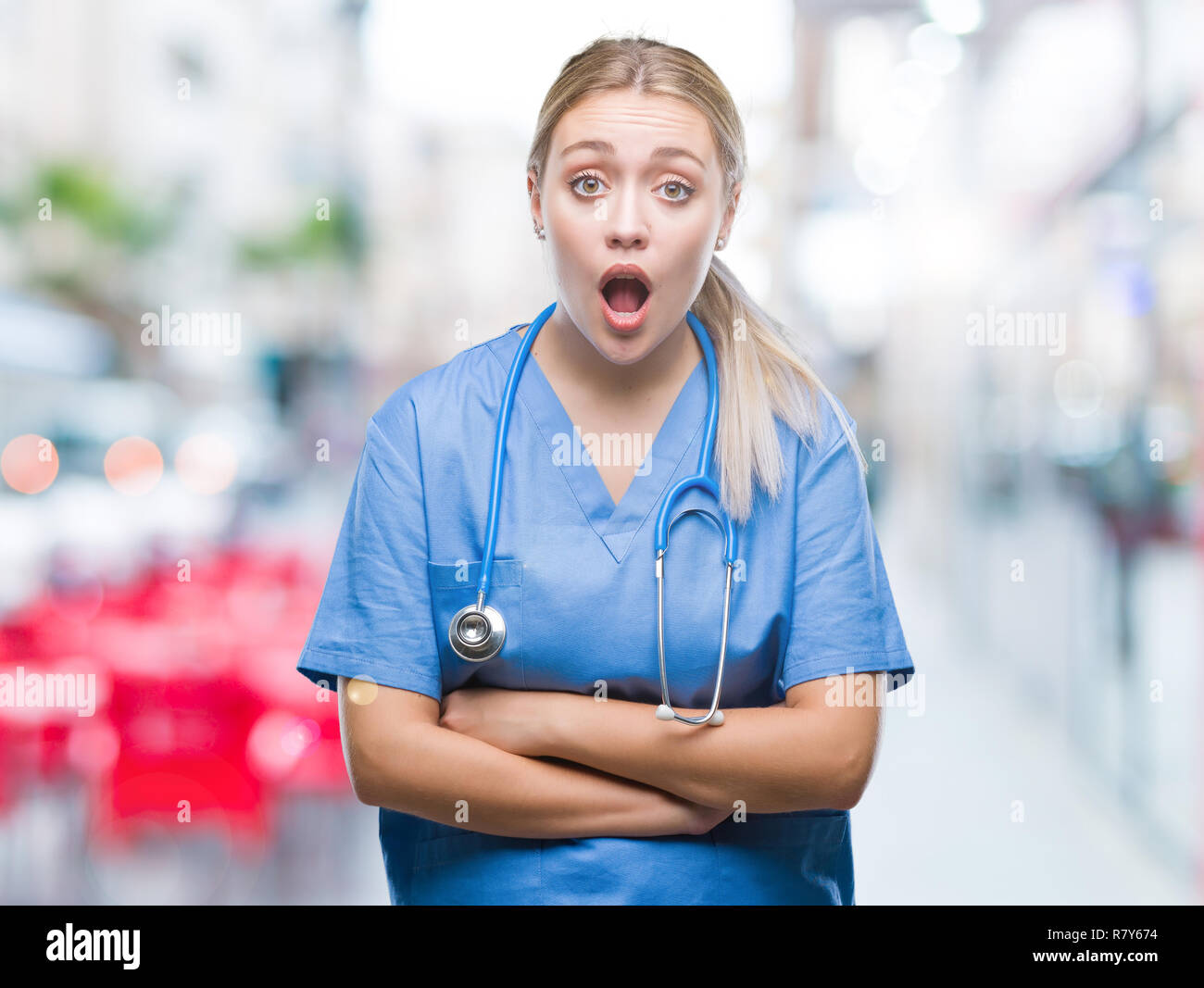 Young blonde surgeon doctor woman over isolated background afraid and ...