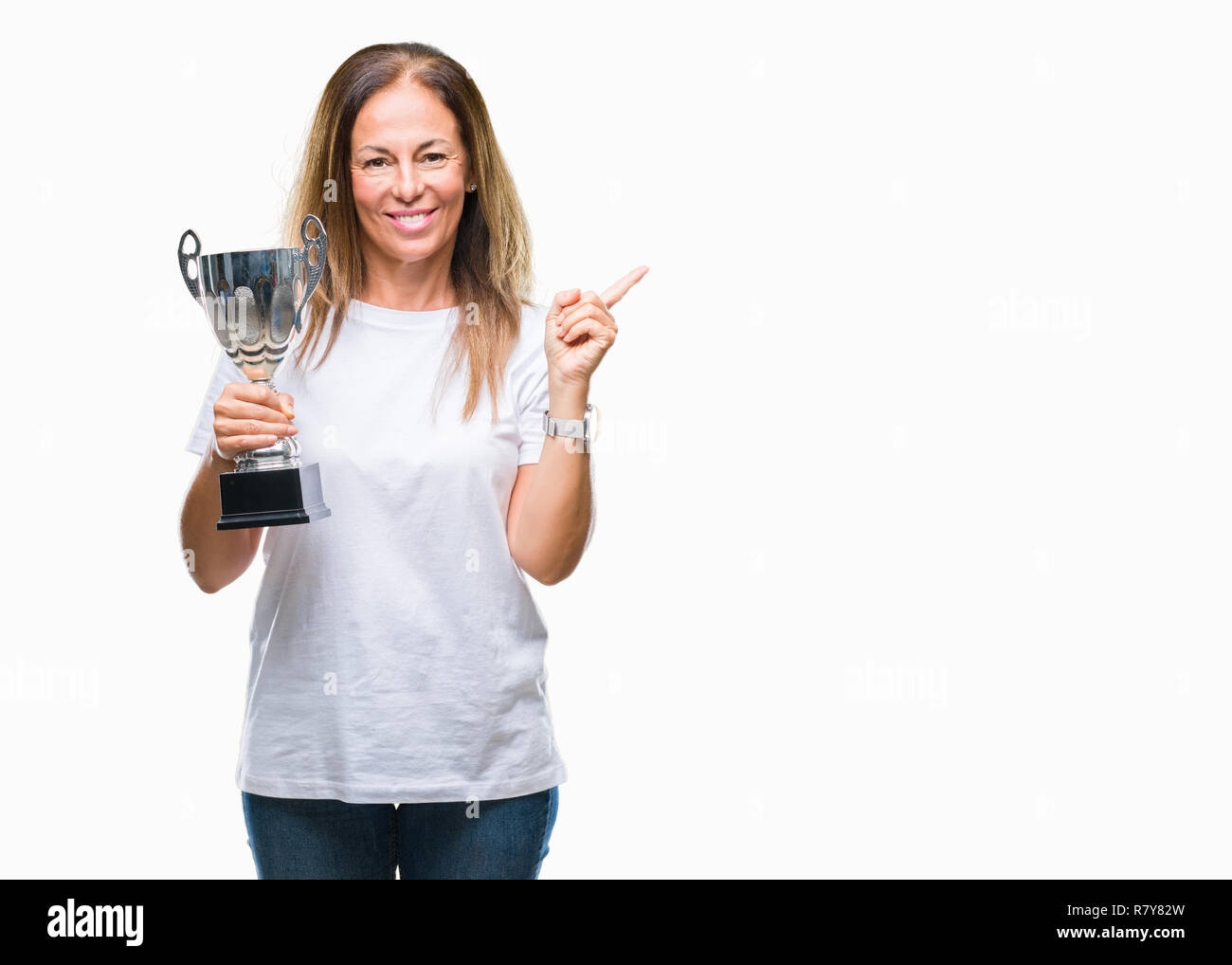 Middle age hispanic winner woman celebrating award holding trophy over ...