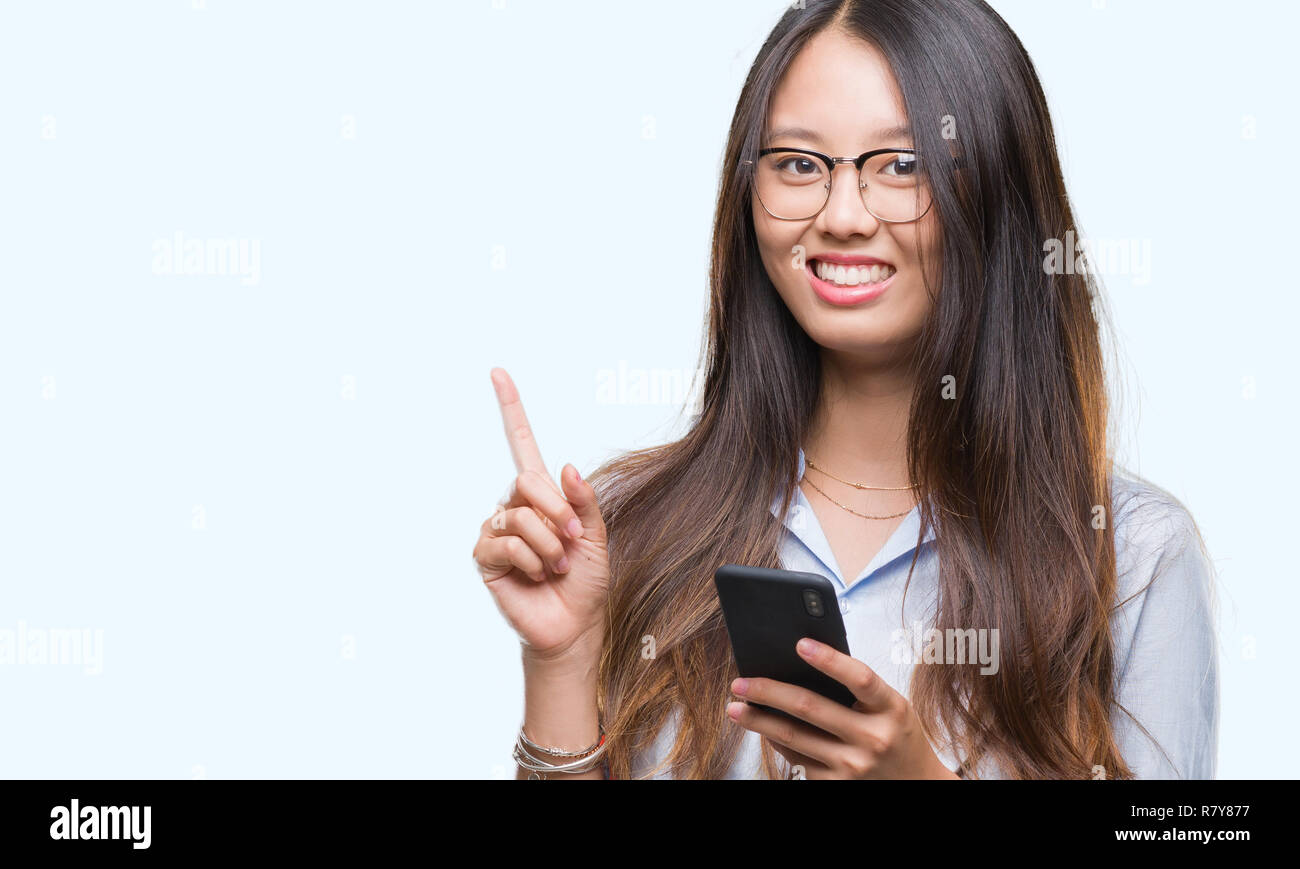Young asian woman texting using smartphone over isolated background ...