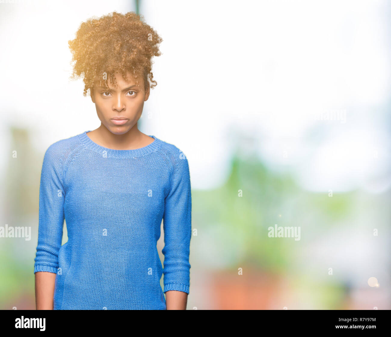 Beautiful young african american woman over isolated background skeptic ...