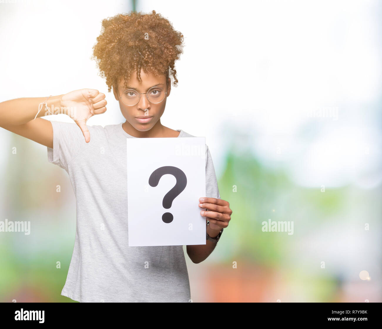 Young african american woman holding paper with question mark over ...