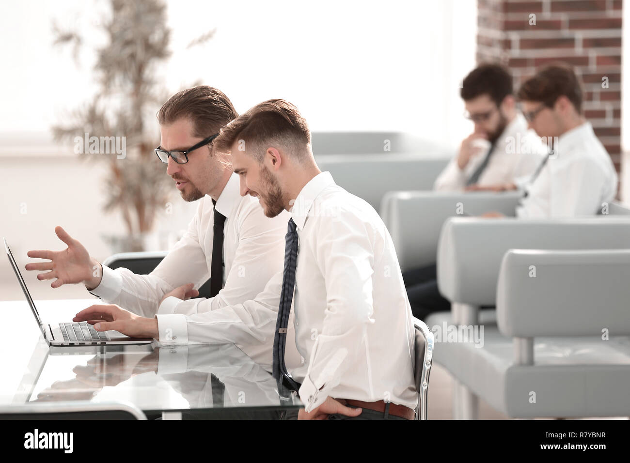 employees sitting at a Desk in a modern office Stock Photo - Alamy