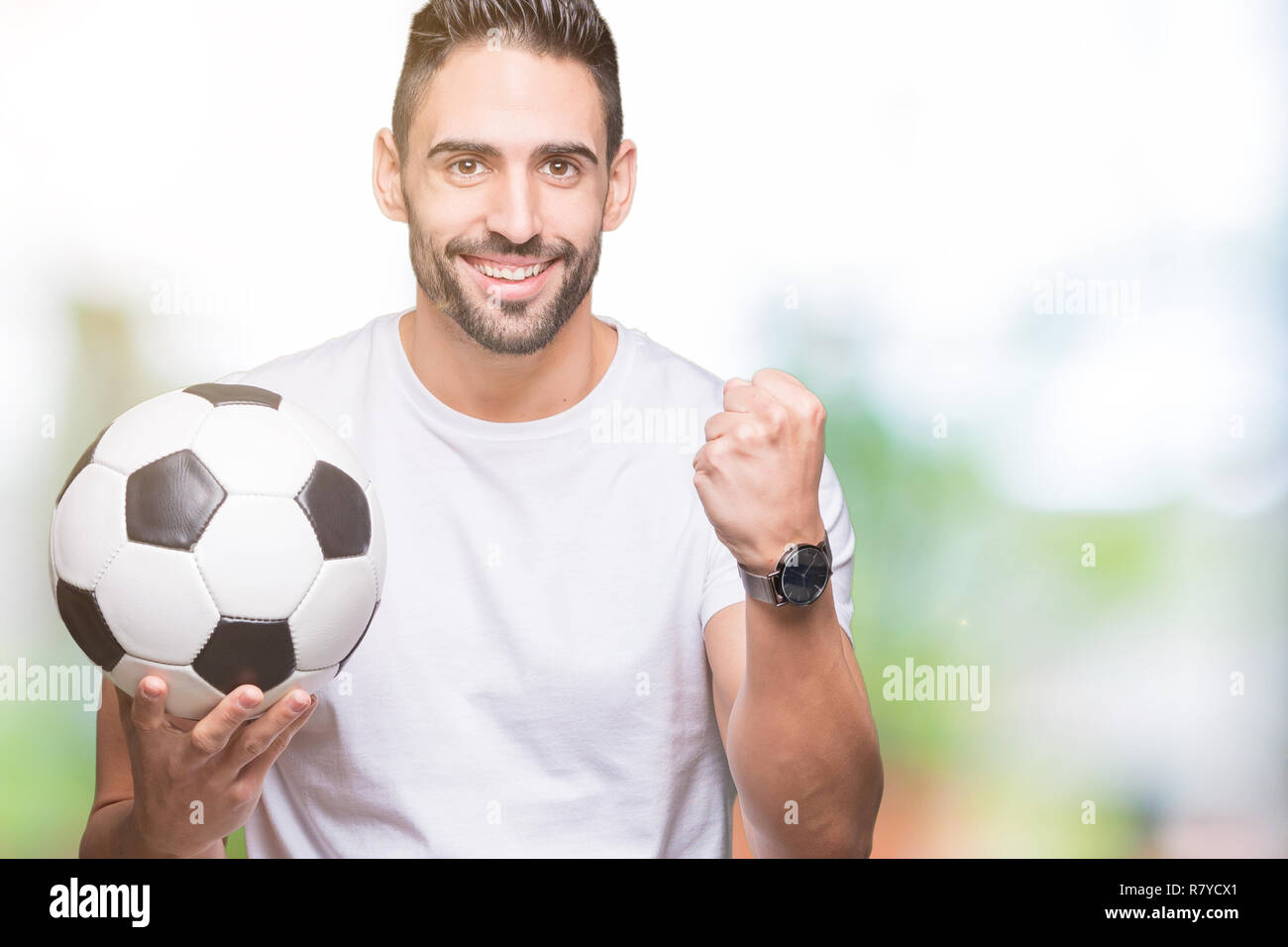 Young man holding soccer football ball over isolated background ...