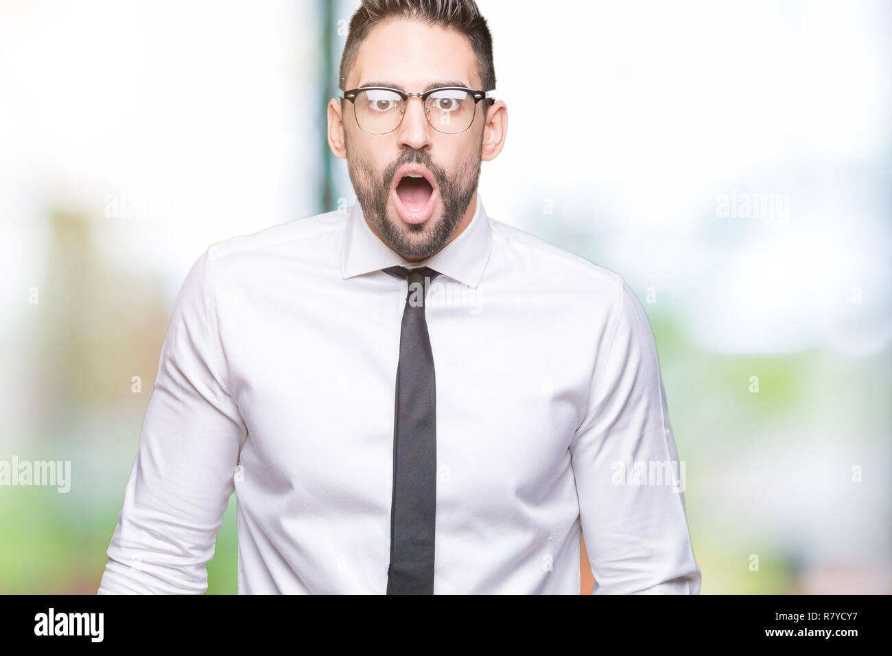 Young handsome business man wearing glasses over isolated background In shock face, looking ...