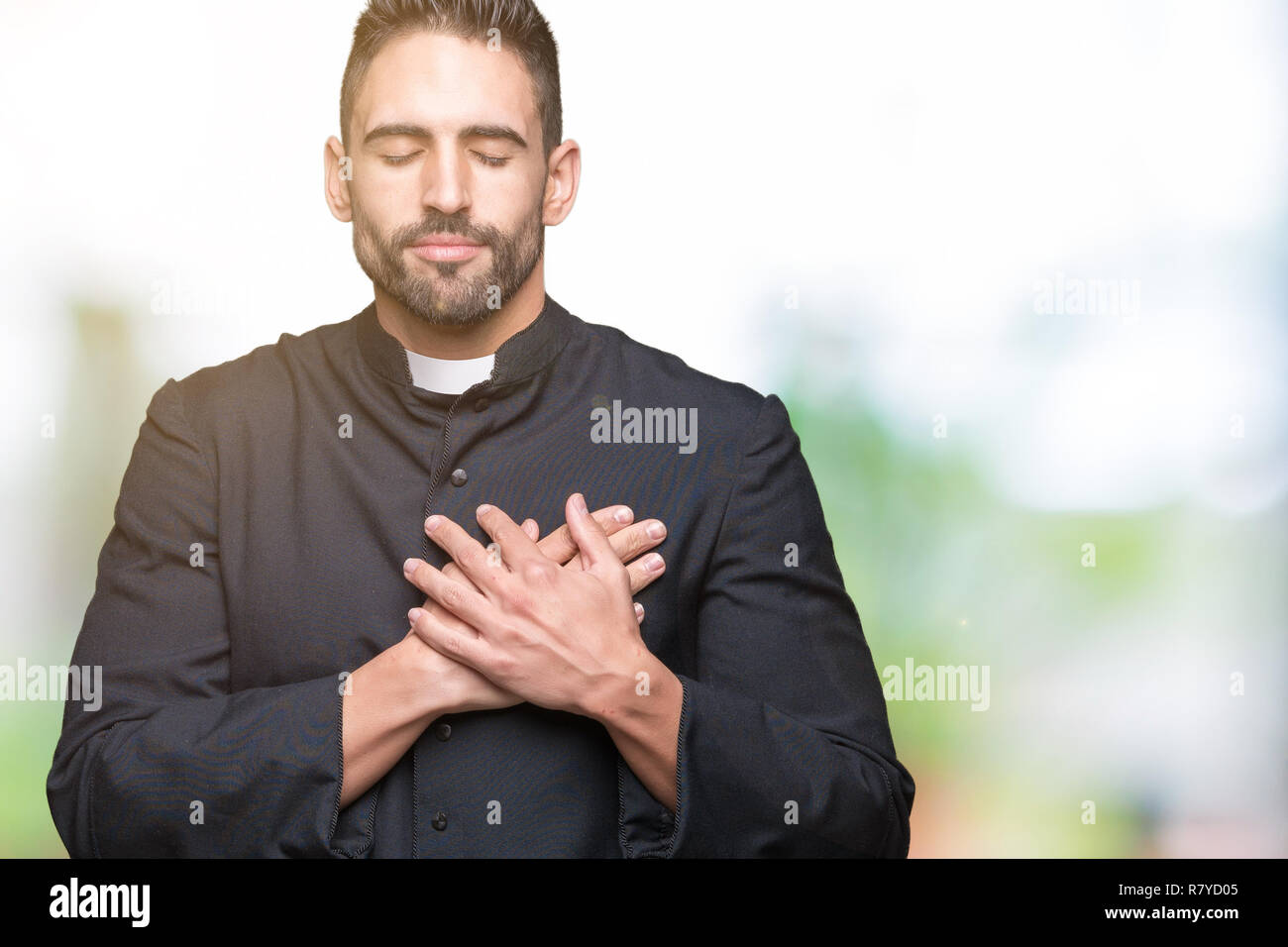 Young Christian priest over isolated background smiling with hands on ...