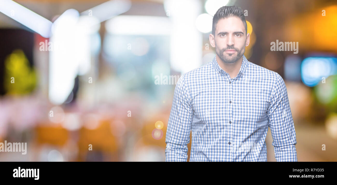 Young handsome man over isolated background Relaxed with serious ...